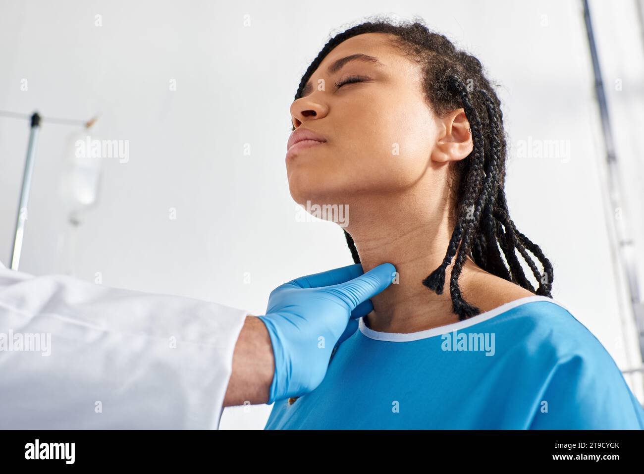 sick pretty african american woman closing eyes while her indian doctor ...