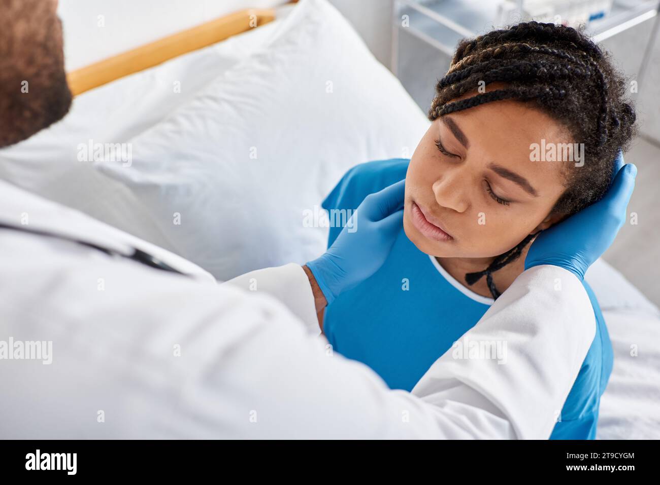 sick pretty african american woman closing eyes while her indian doctor ...