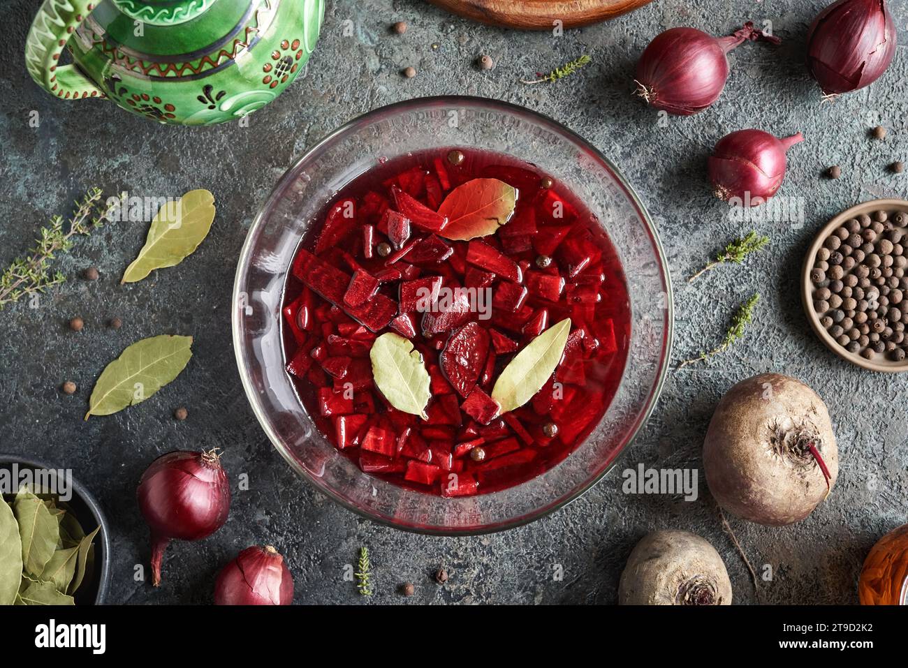 Fermented red beet kvass in a glass bowl with onions and spices, top ...