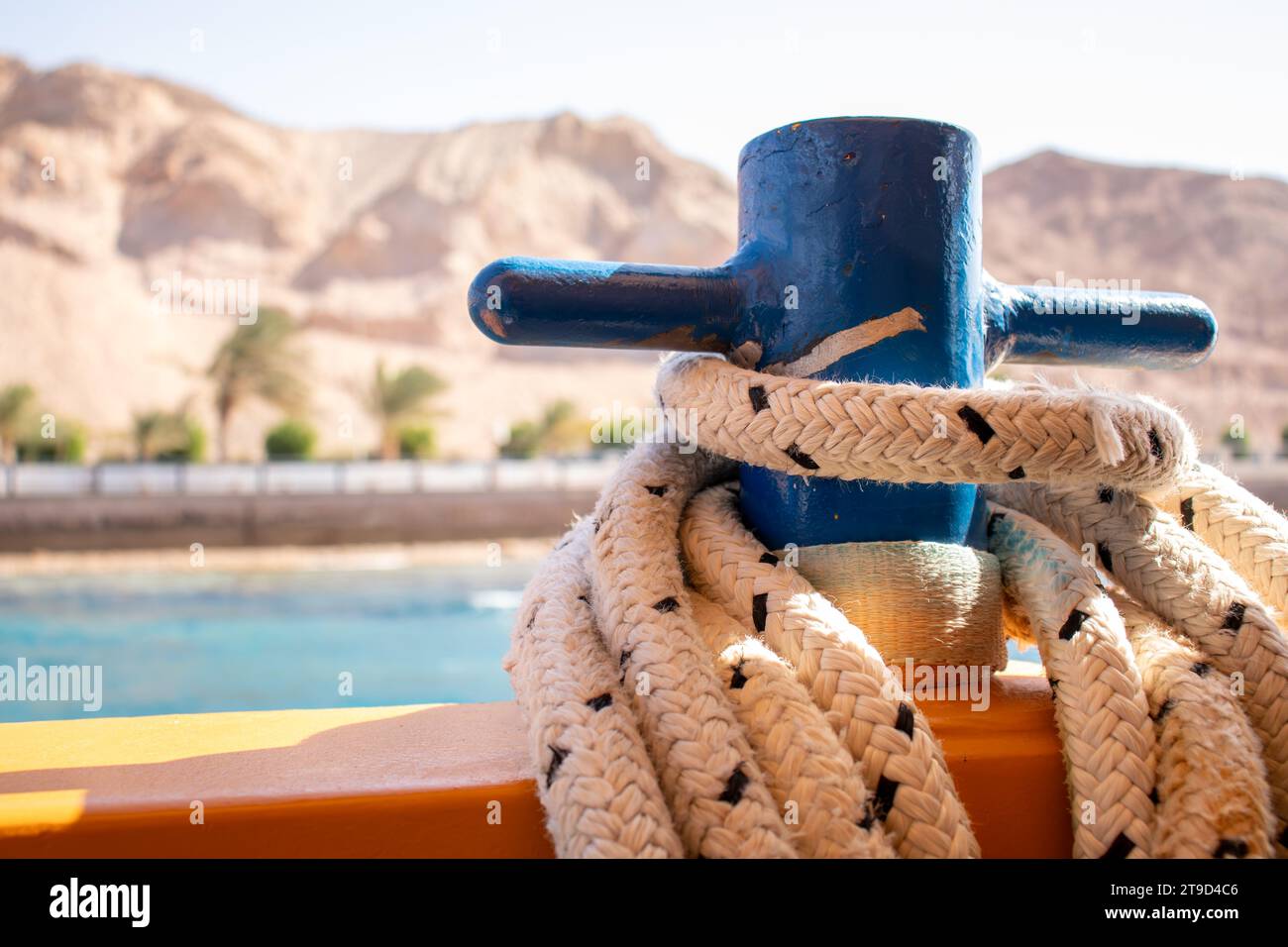 Bollards on ship with ropes at the sea in the background used for ...
