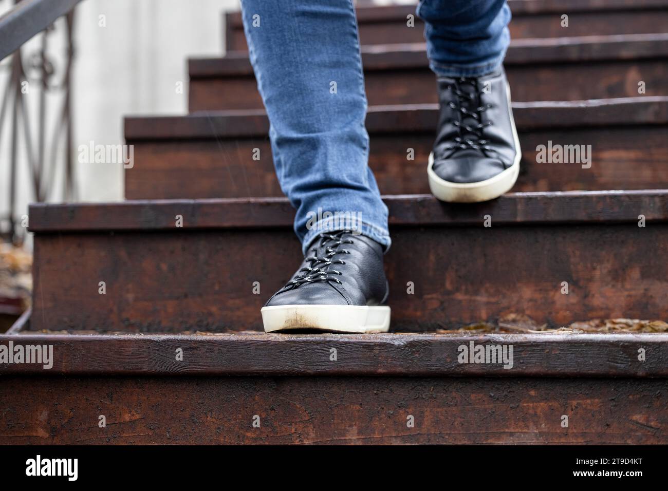 man going down wooden stairs in rainy weather. shoe steps on a wooden ...