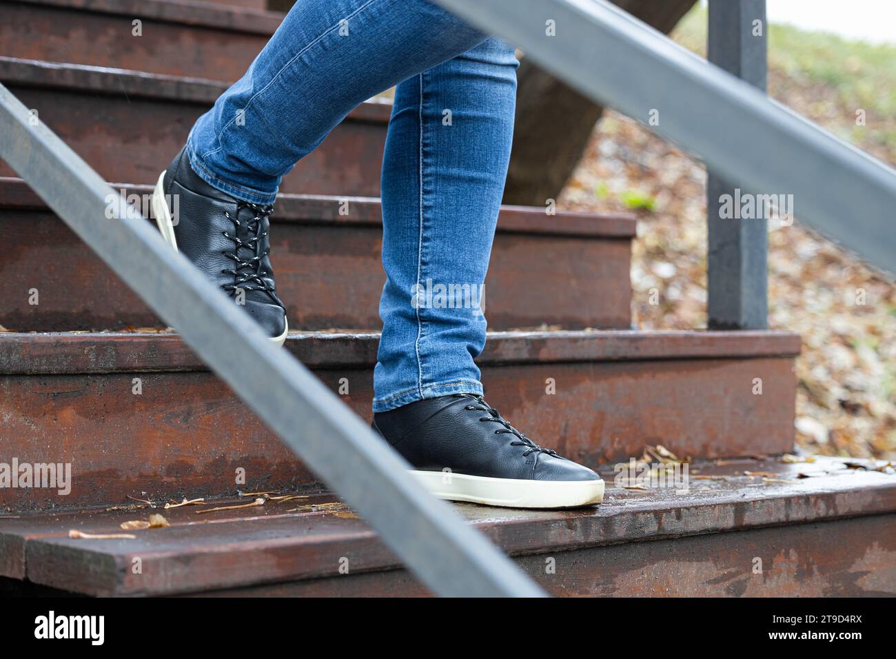 man going down wooden stairs in rainy weather. shoe steps on a wooden ...