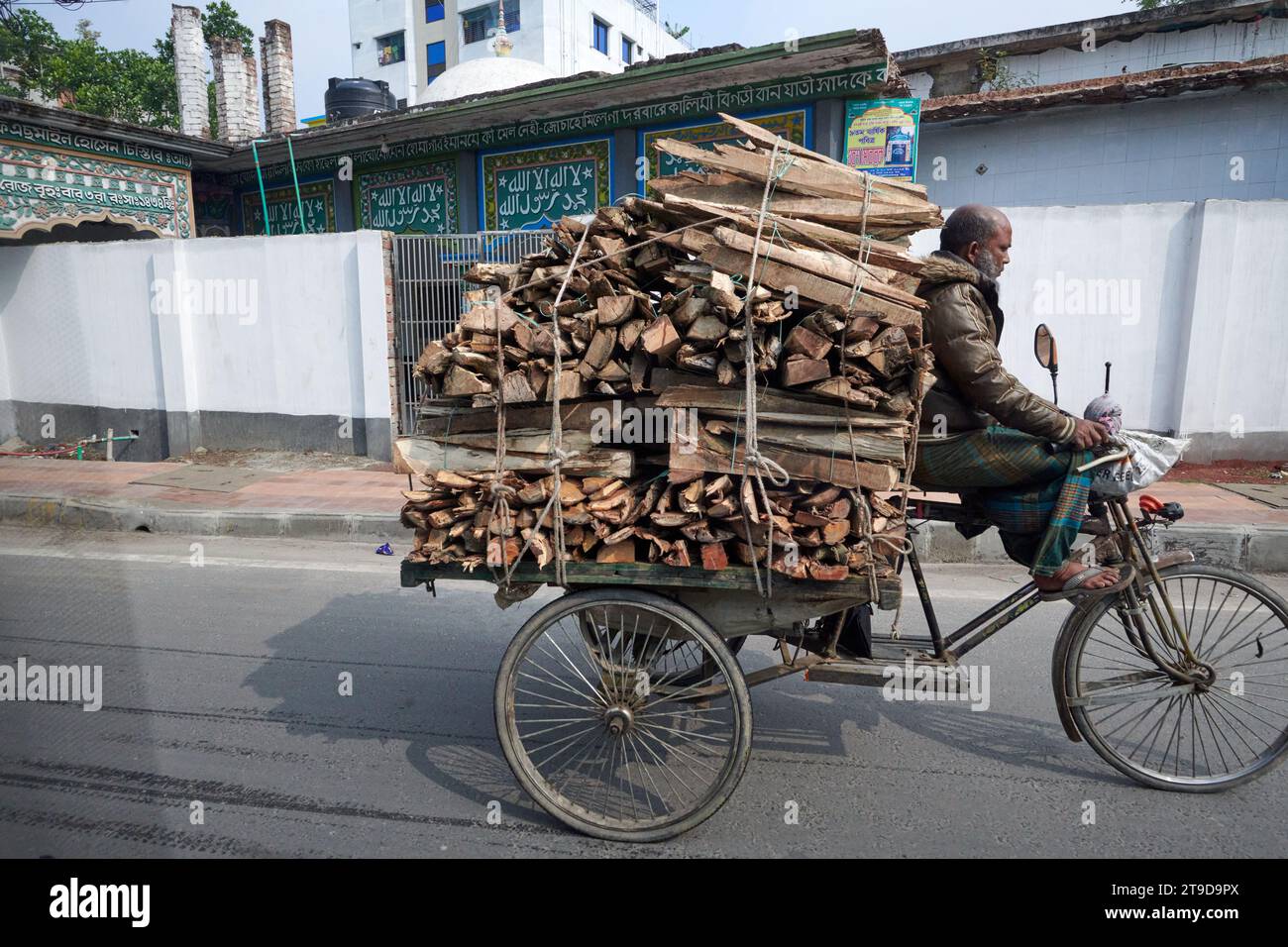 Man transporting wood on a tri-bike in a city in Bangladesh Stock Photo ...