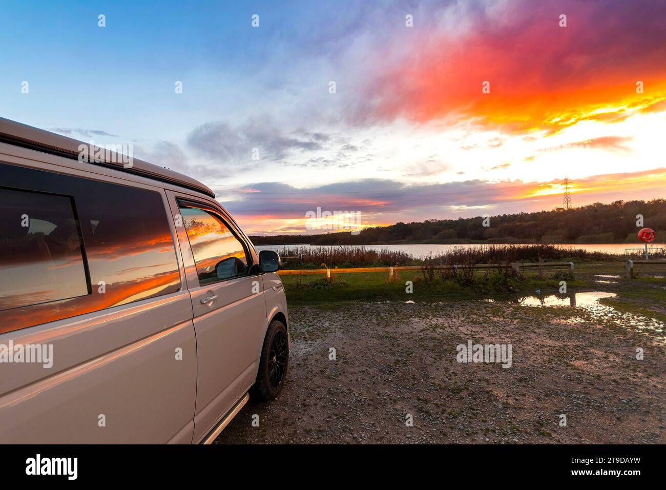 Volkswagen T6 campervan with reflection of sunset over the lake at ...