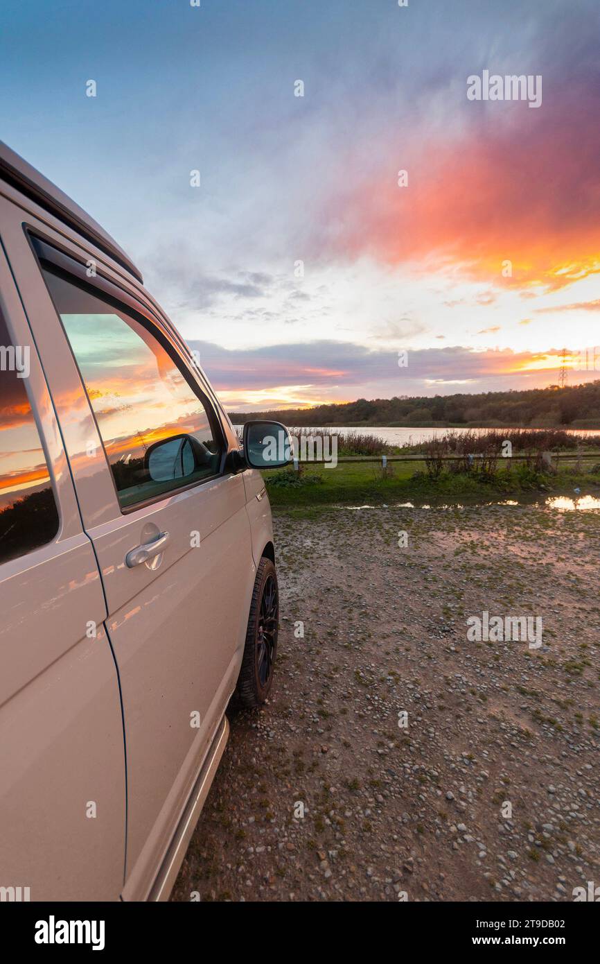 Volkswagen T6 campervan with reflection of sunset over the lake at ...