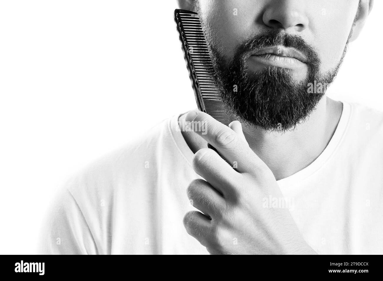 Man combing his thick beard on white background Stock Photo - Alamy