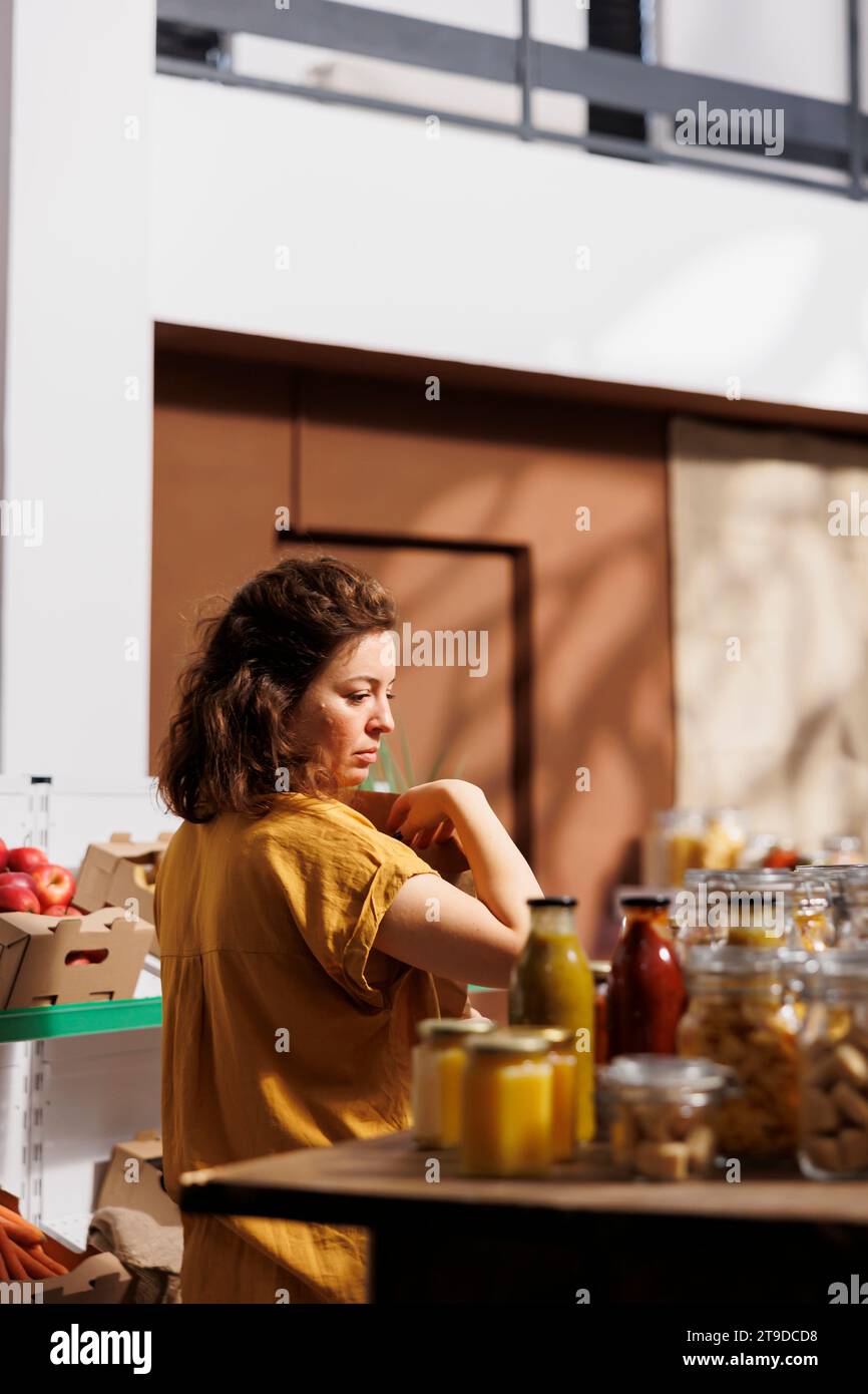 Shopper buying mindfully, picking bio produce in zero waste store using ...