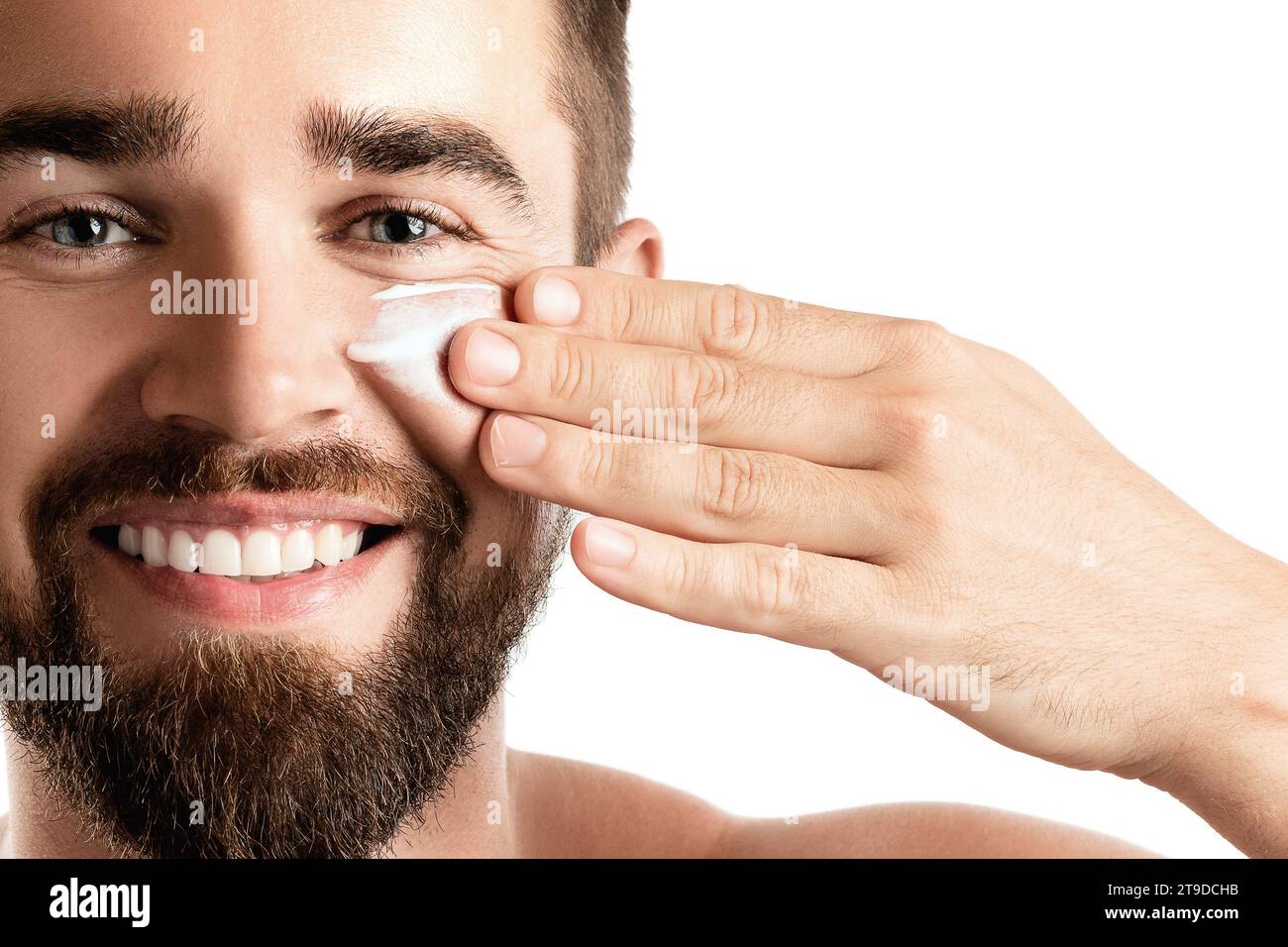 Men's beauty - Young man is applying moisturizing and anti aging cream ...