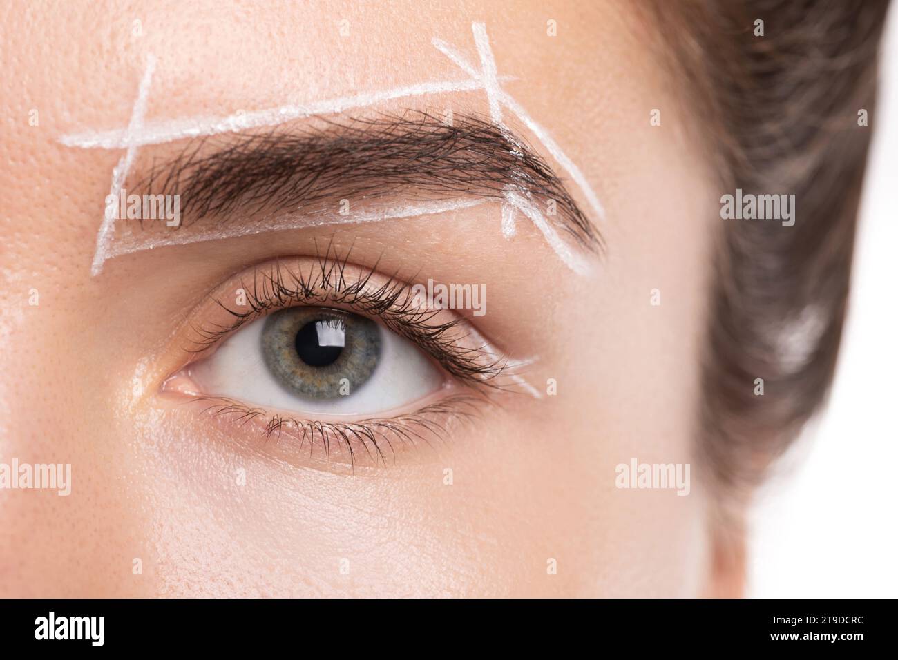 Closeup of female face during professional eyebrow mapping procedure ...