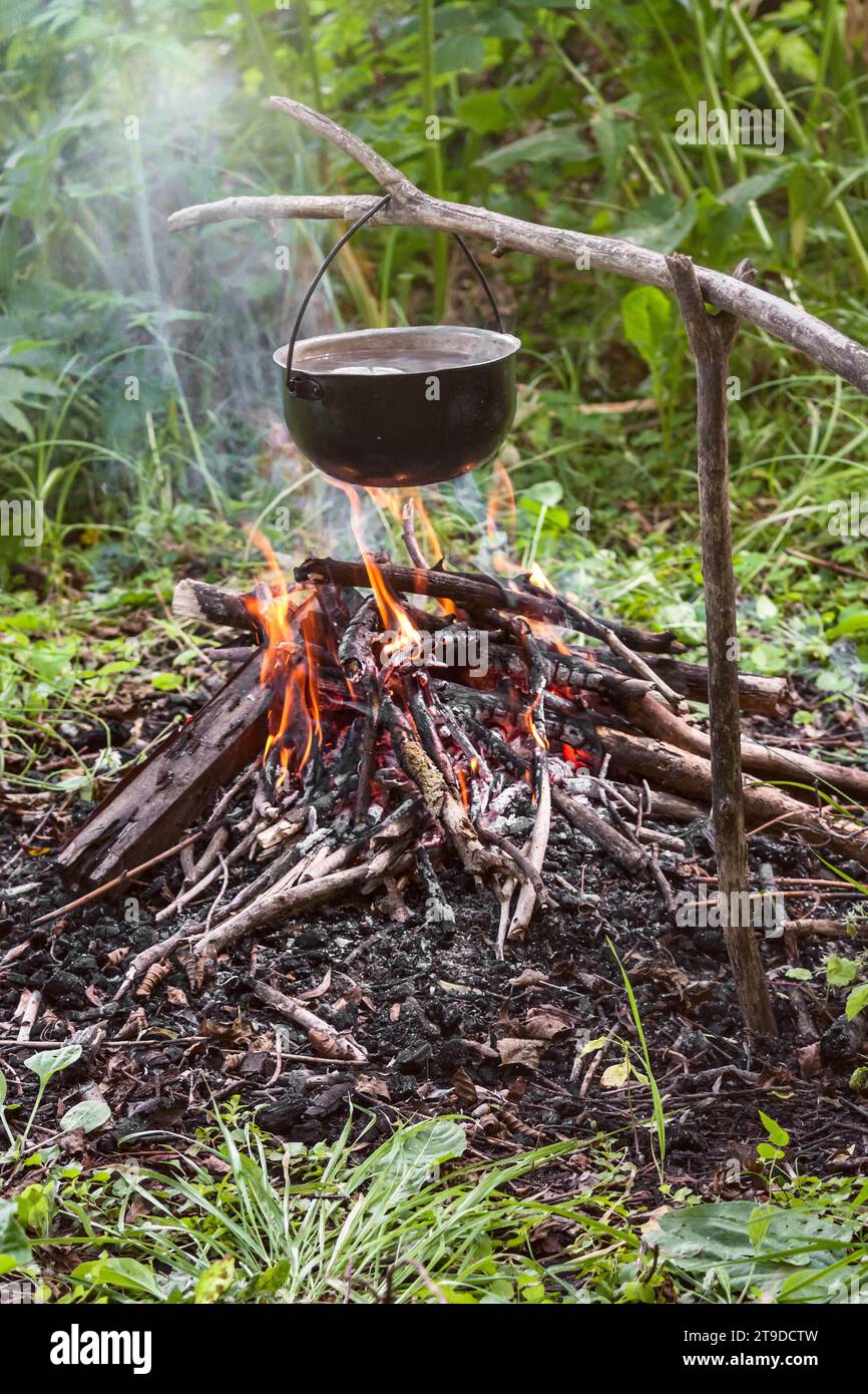 Hiking pot in the bonfire, cooking food in a field tent camp Stock ...