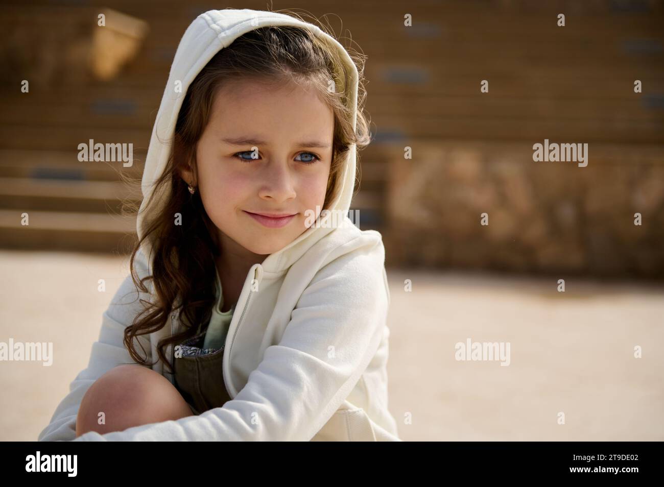 Close-up elementary age Caucasian child, adorable little girl with hood ...