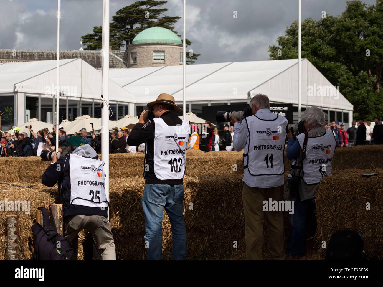 Professional photographers wearing vests capturing an event, stands and ...