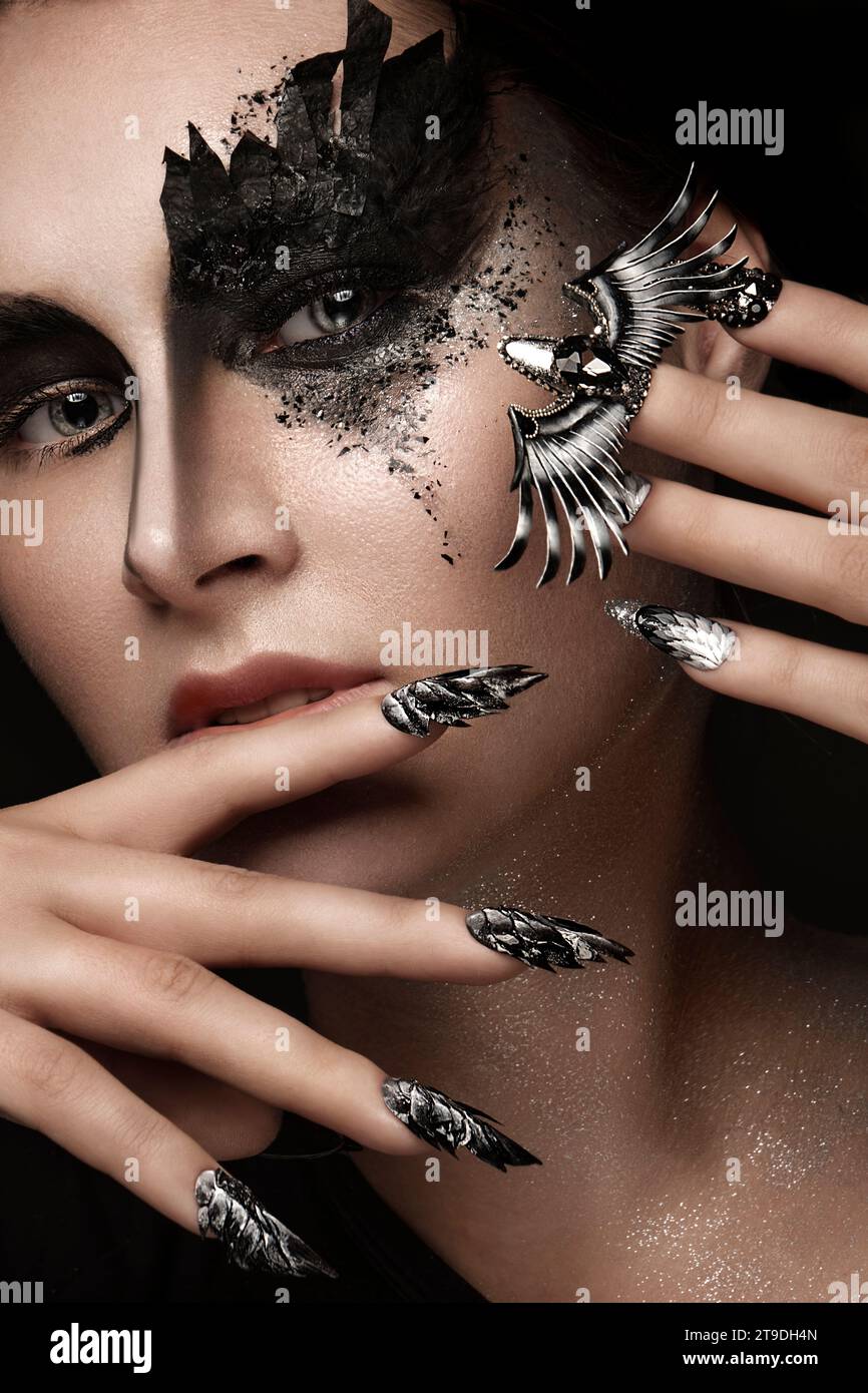 Portrait of a beautiful woman with art make-up, creative long nails ...