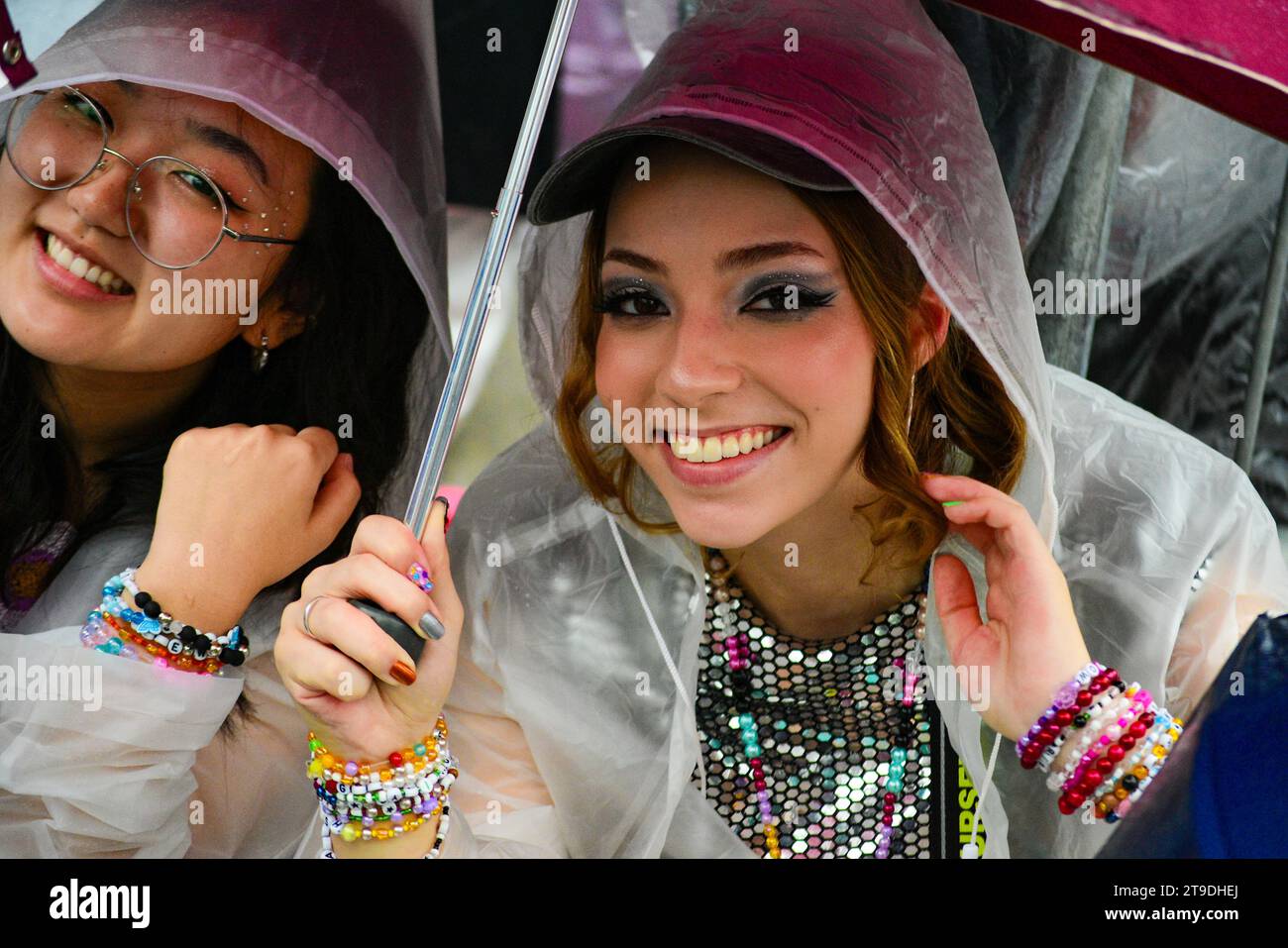 Fans take shelter from the rain in line to watch singer Taylor Swift's ...