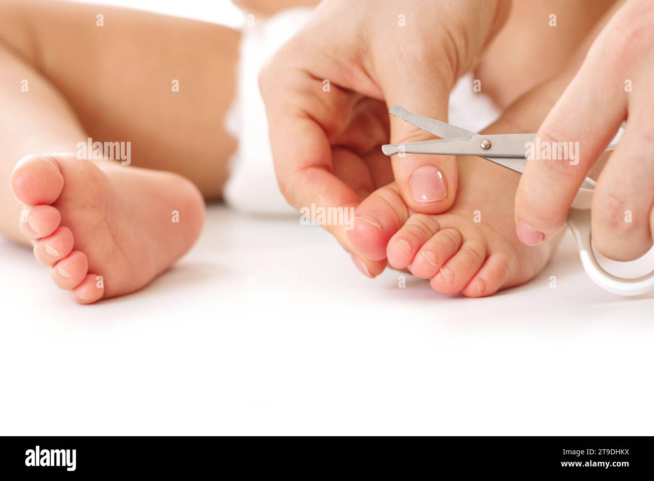 Closeup shot of a mother gently holding her little child's foot and ...