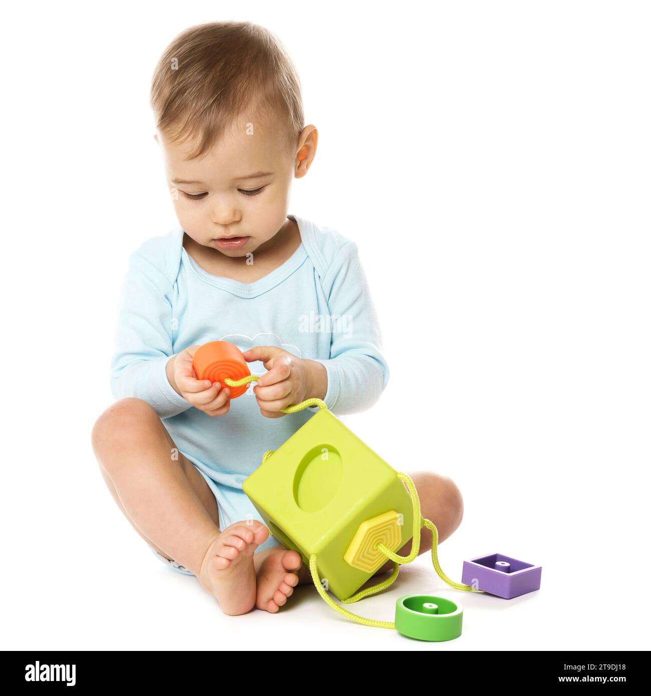 Adorable little boy in a romper is sitting and playing with plastic toy ...