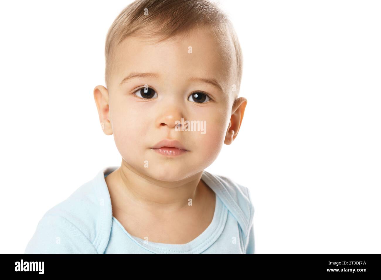 Closeup shot of a curious face of an adorable little boy in a romper on ...