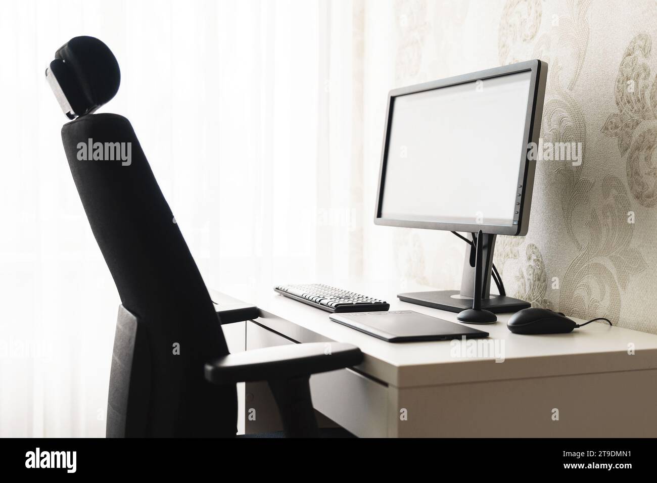 Home office workplace with a chair, desk and a desktop computer with ...