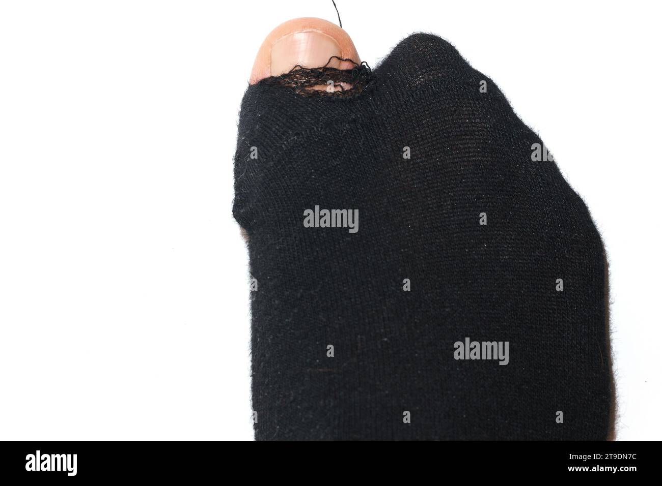 Closeup shot of a black holey sock on a male foot with toe sticking out ...