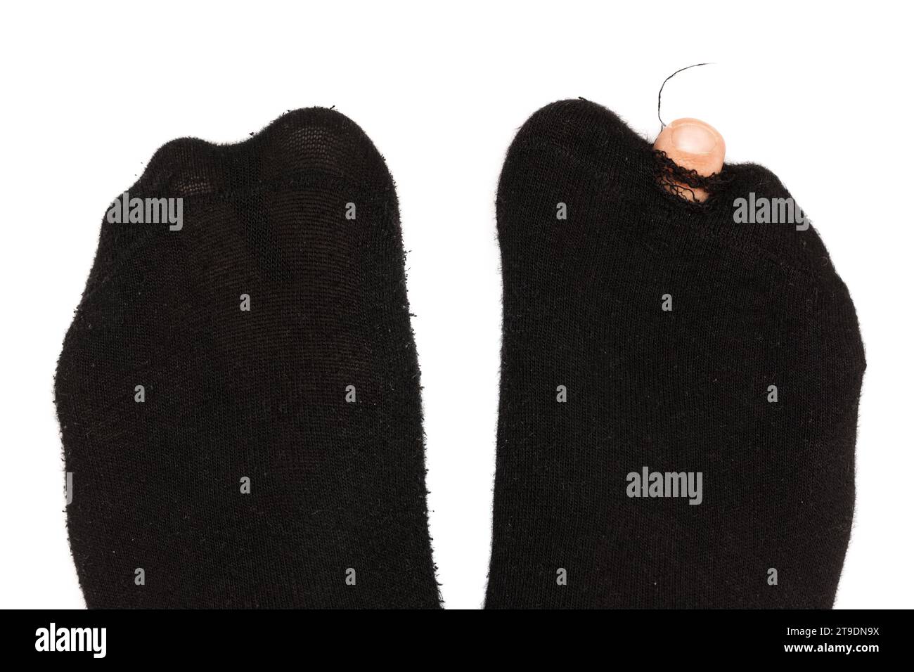 Closeup shot of male feet in old hoaly socks with a toe sticking out on ...