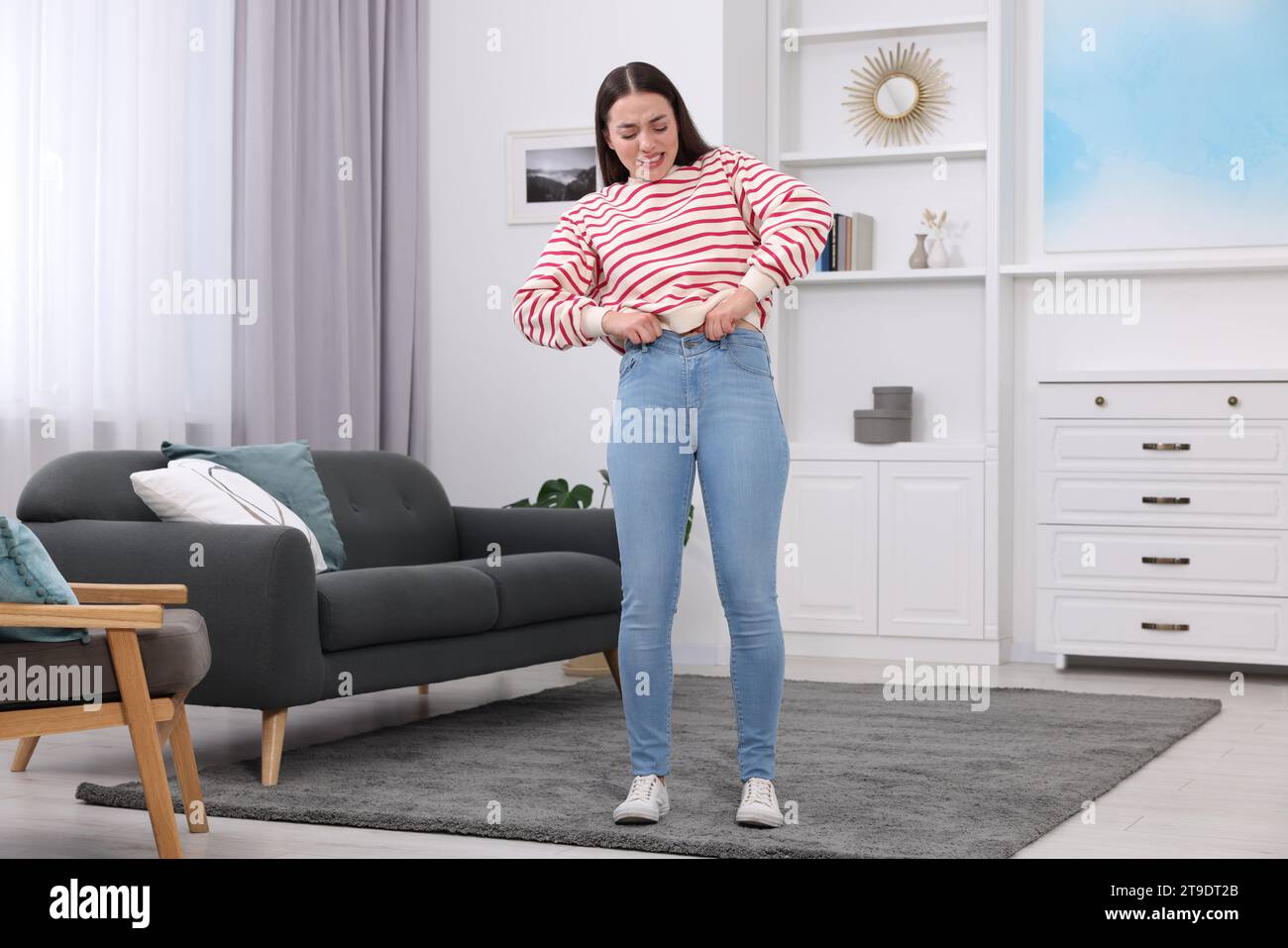 Woman struggling tight jeans hi-res stock photography and images - Alamy