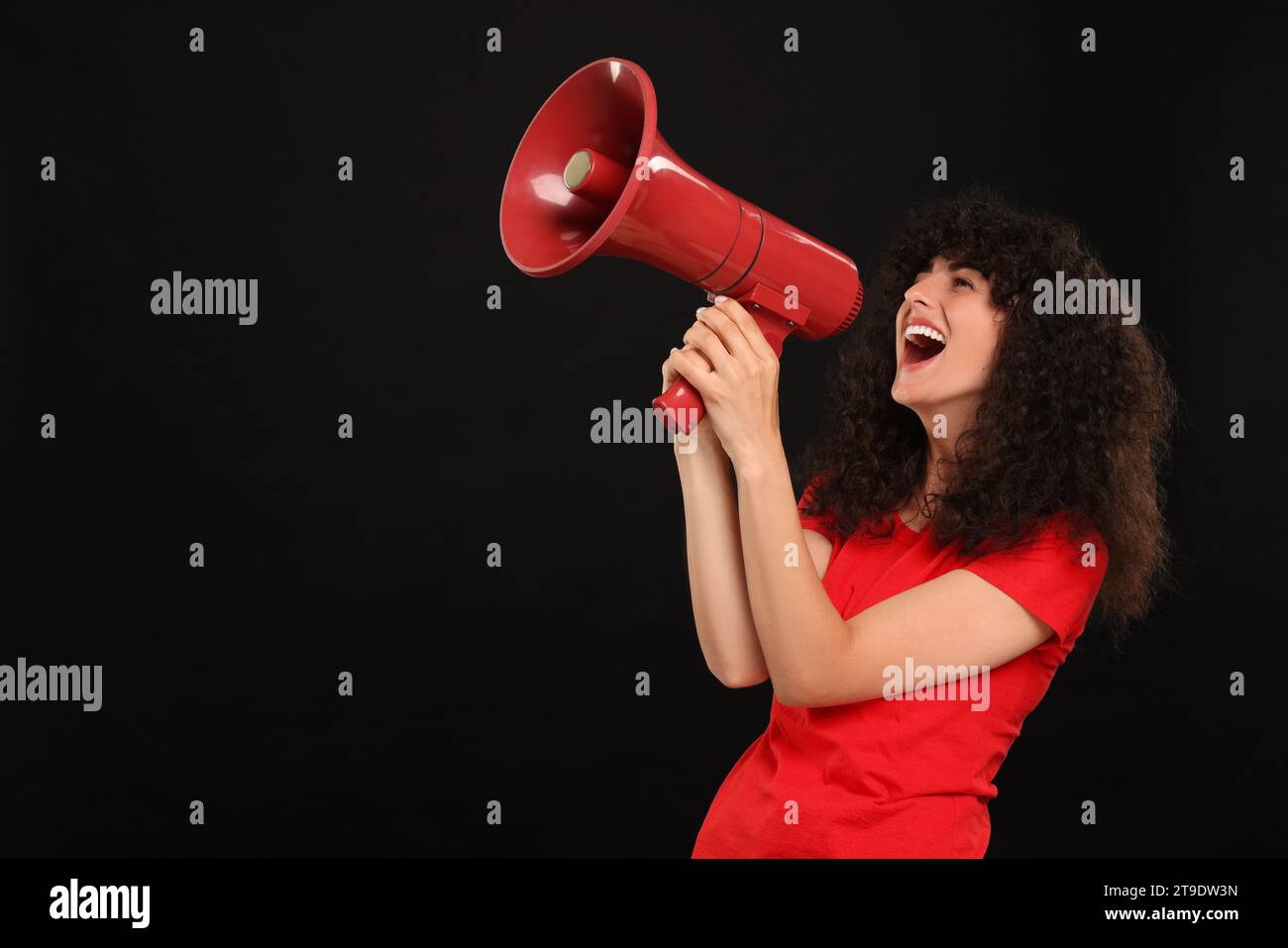 Happy fan using megaphone on black background, space for text Stock ...