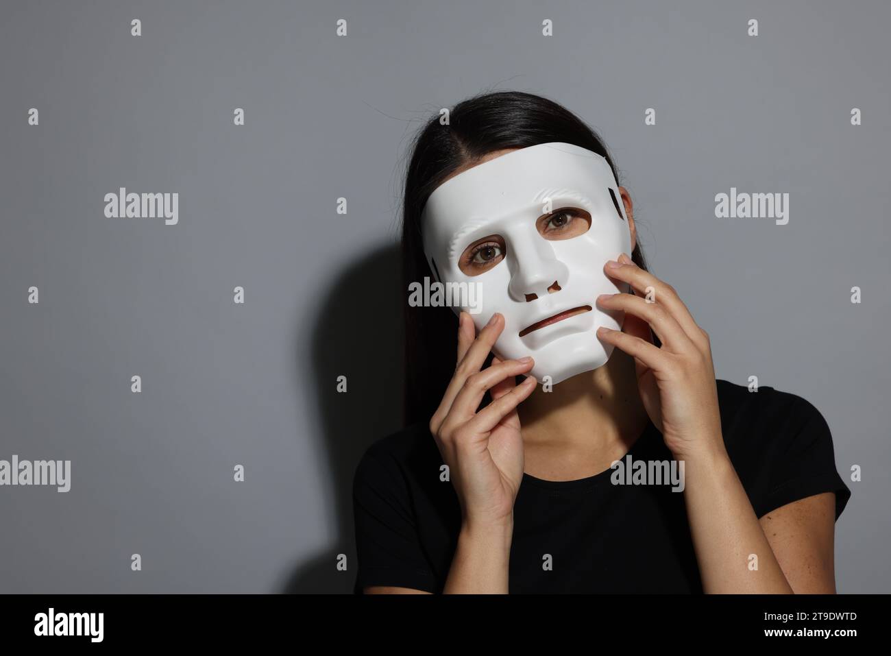 Multiple personality concept. Woman in mask on grey background, space ...