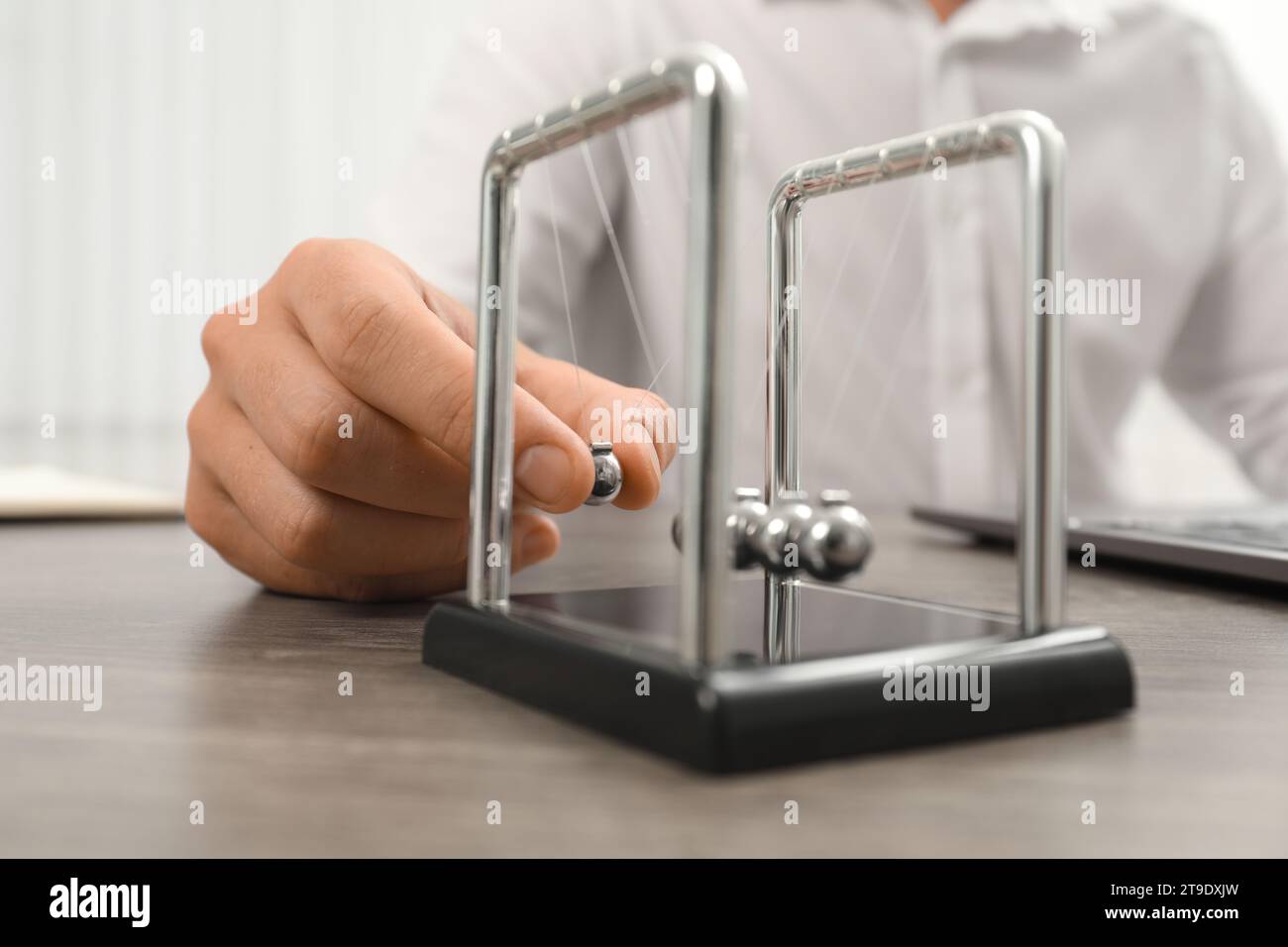 Newton's cradle and hand hi-res stock photography and images - Alamy