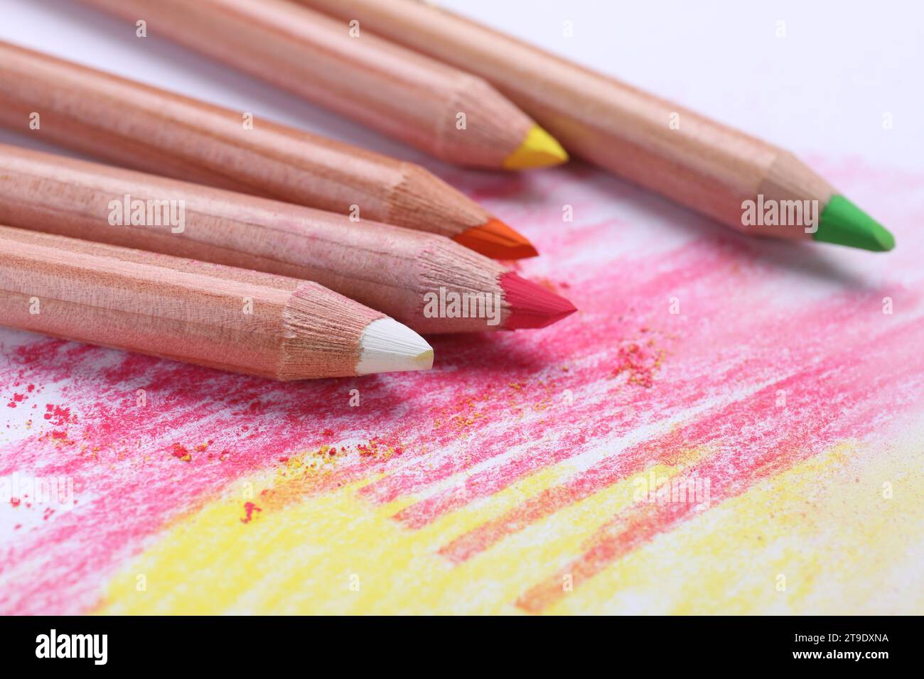 Colorful pastel pencils and scribbles on white background, closeup ...