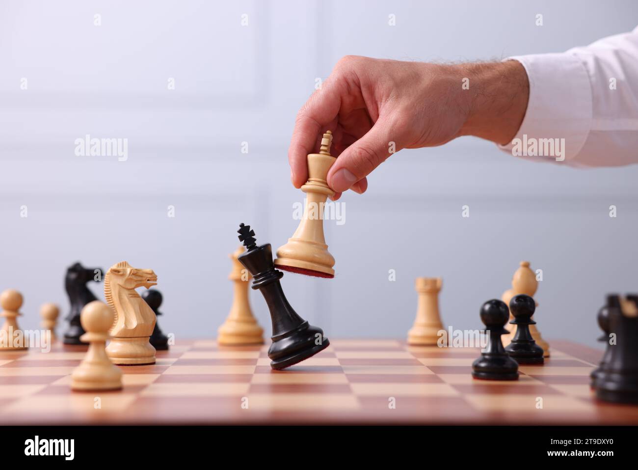 Man moving king chess piece at checkerboard indoors, closeup Stock ...