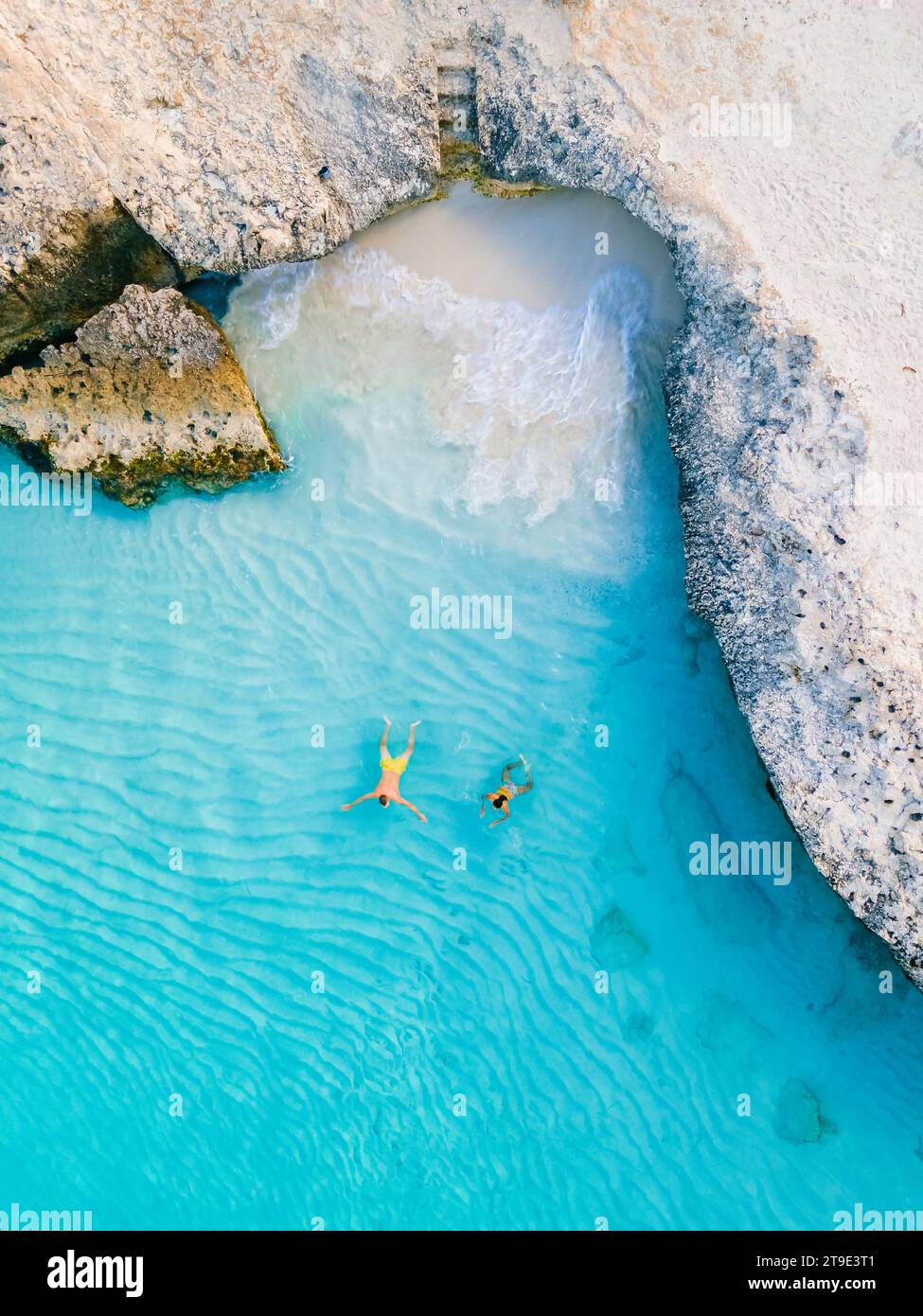 A couple of men and woman in a crystal clear ocean in the Caribbean ...