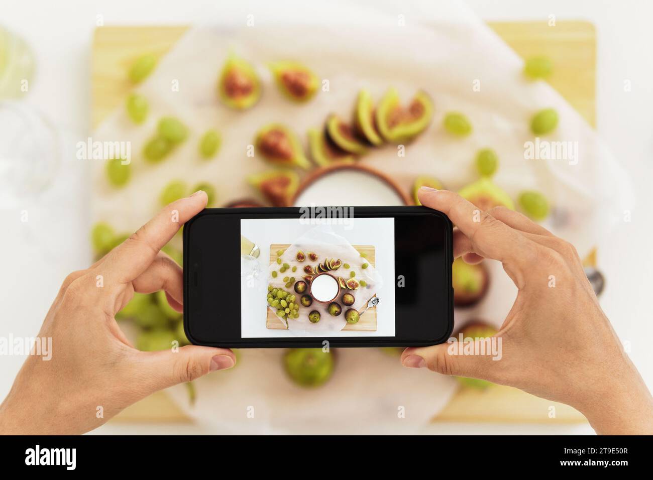 Woman taking photo of her delicious Greek yogurt with figs by her ...