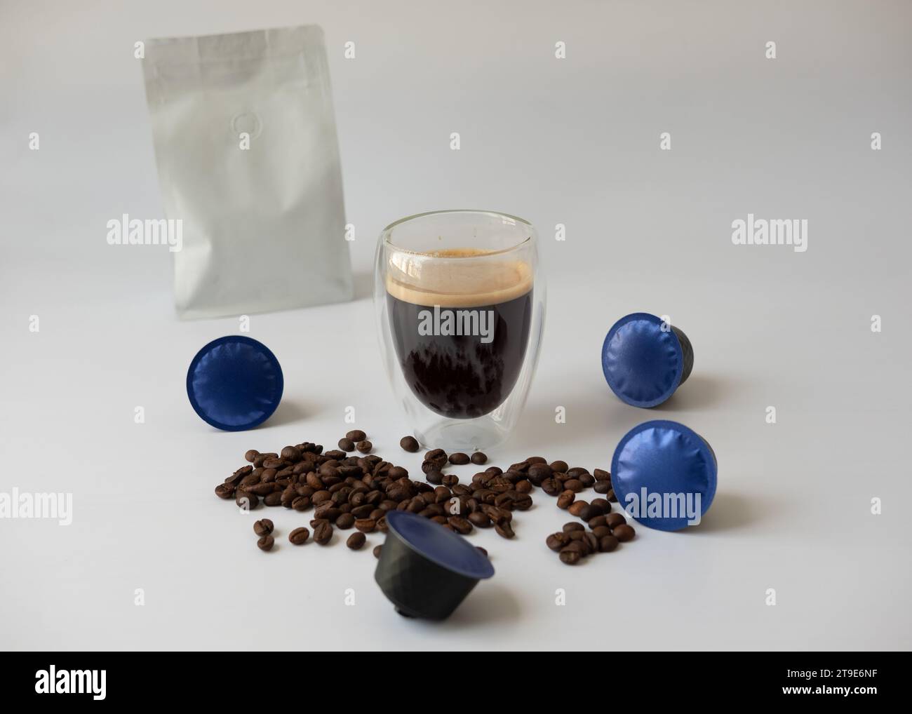Coffee mug with crema with coffee capsule elements, coffee beans, on a ...