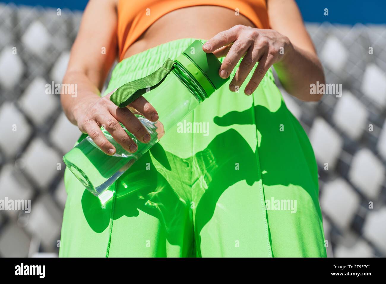Closeup of female hands with green reusable bottle of water Stock Photo ...