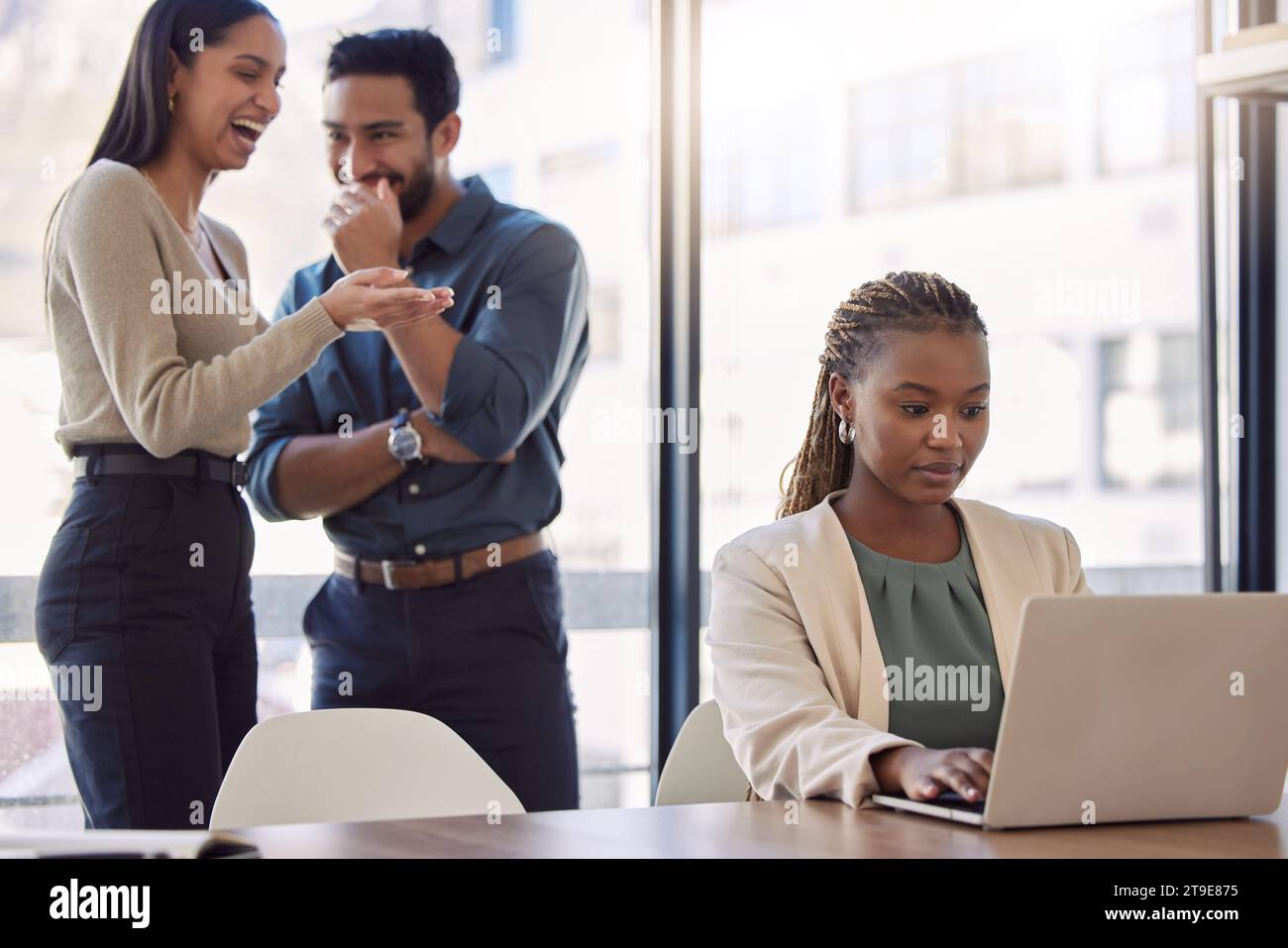 Office bully, woman and working at laptop with coworkers laughing in a ...