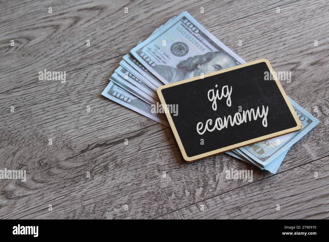 Chalkboard with text GIG ECONOMY on top of money with copy space ...