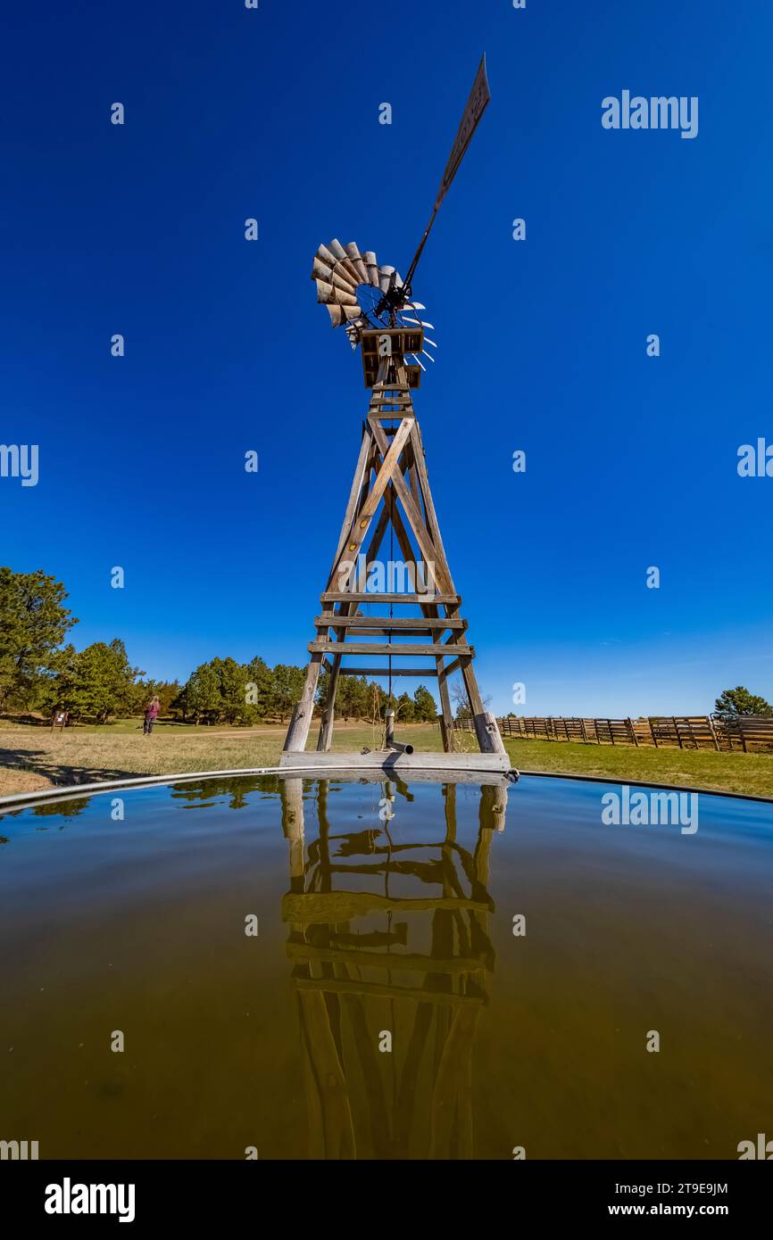 Windmill with wooden town structure pumping water for cattle and ...