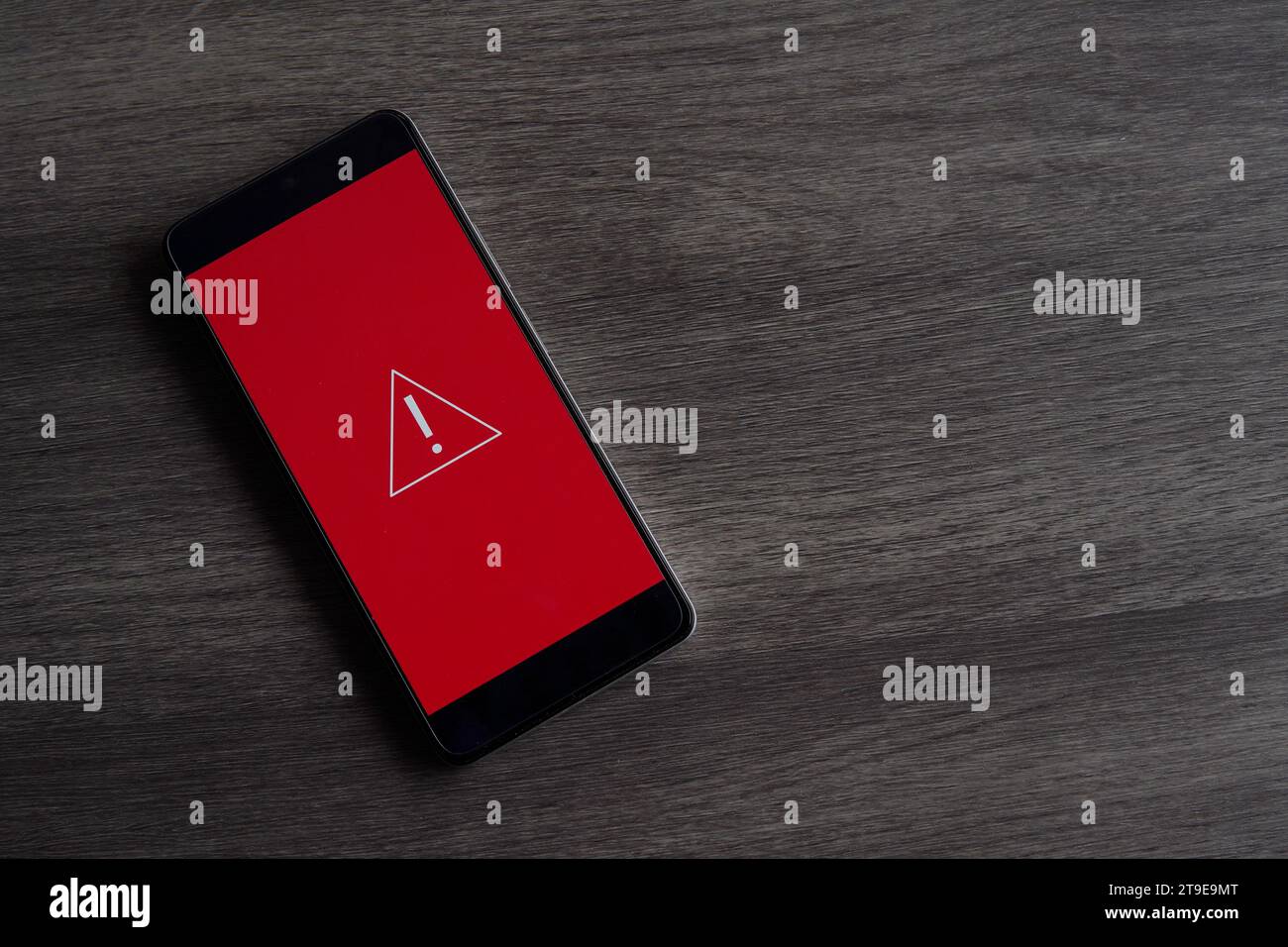 Smartphone with triangle caution warning icon. Copy space for text ...
