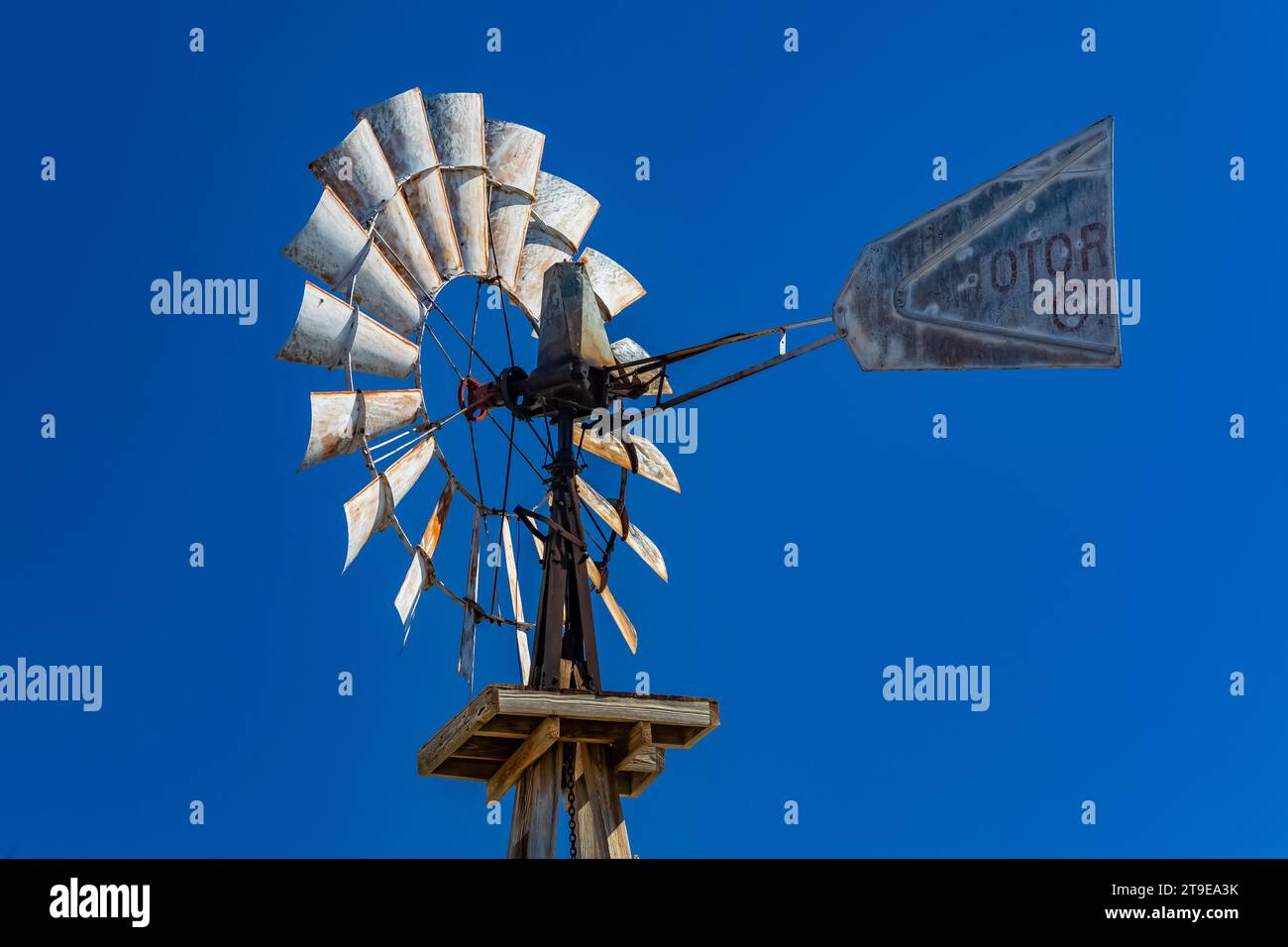 Windmill with wooden town structure pumping water for cattle and ...