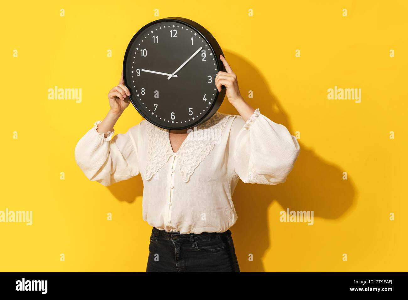 Time management concept. Woman covering her face with big clock on ...