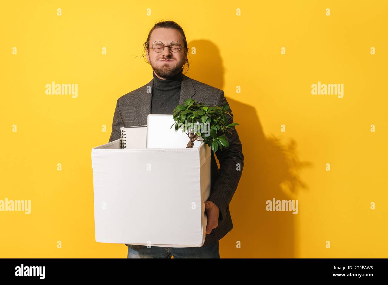 Man with silly face holding box with personal items after job ...