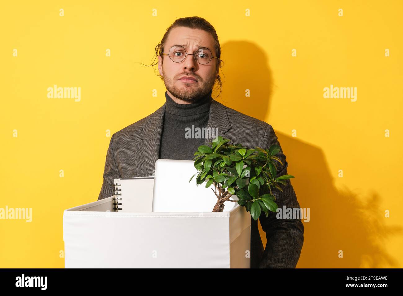 Young upset man holding box with personal items after job resignation ...