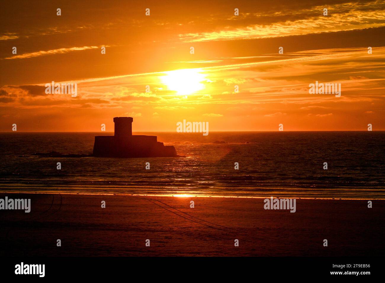 Silhouette of La Rocco Tower. Dynamic sunset at St. Ouen's Bay at low ...