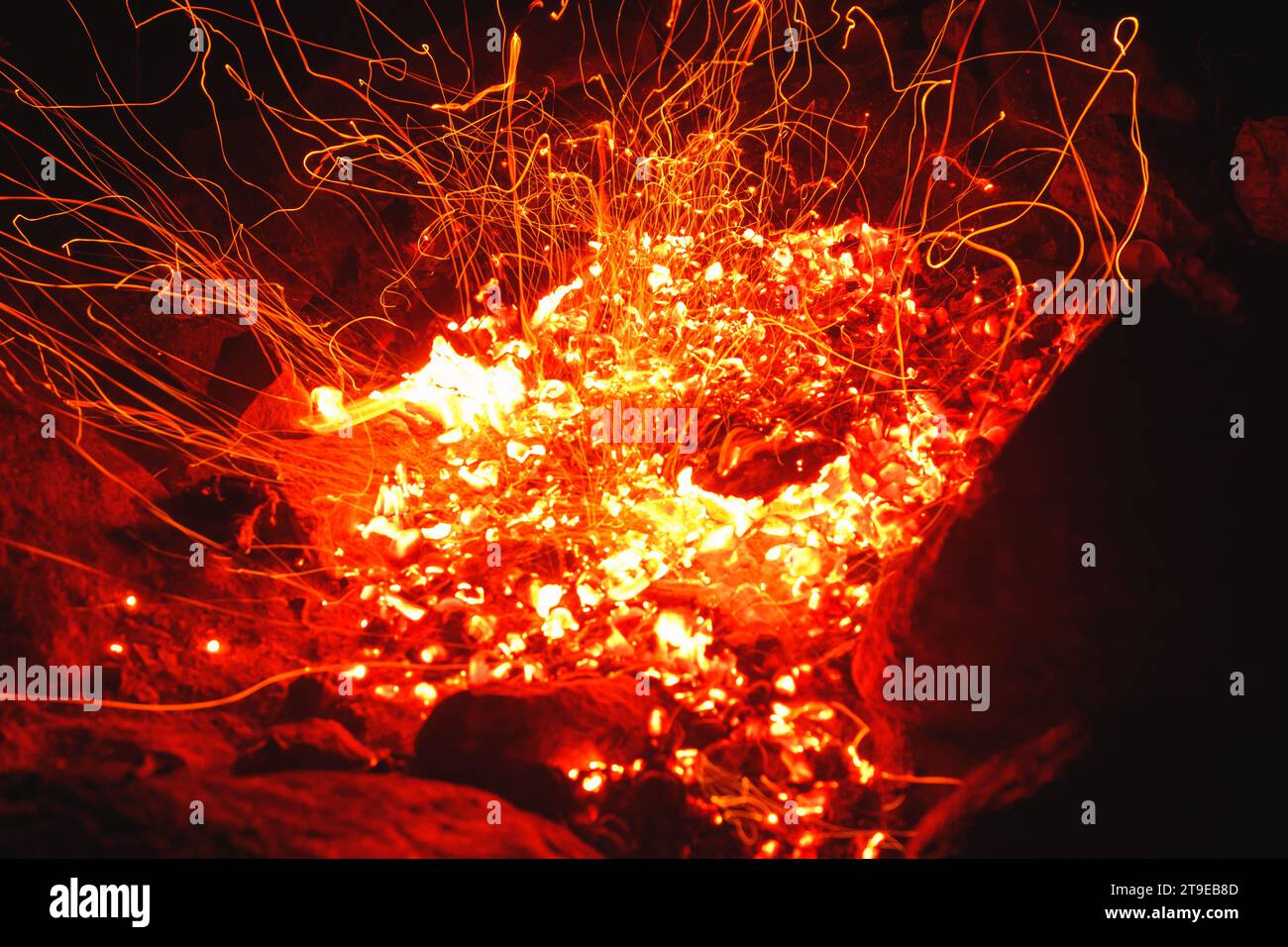 Closeup shot of campfire brightly burning at night and throwing ...