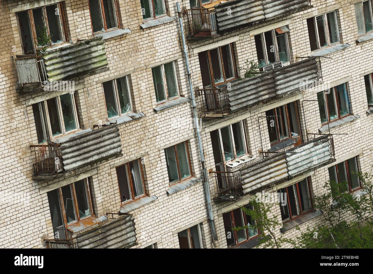 Exterior of an abandoned apartment building with broken windows in a ...
