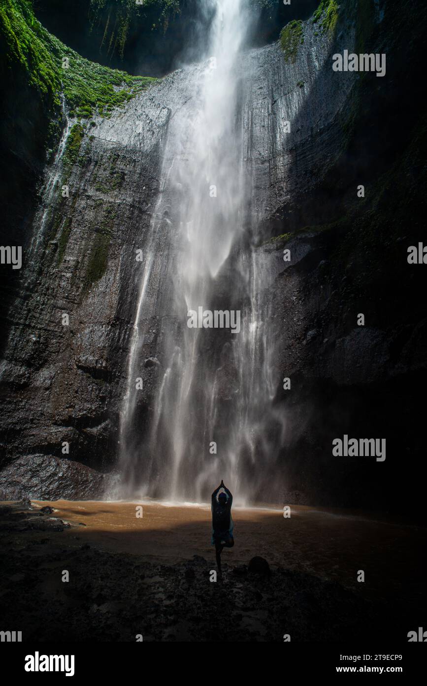 A yoga man in front of the beautiful view of Madakaripura Waterfall ...