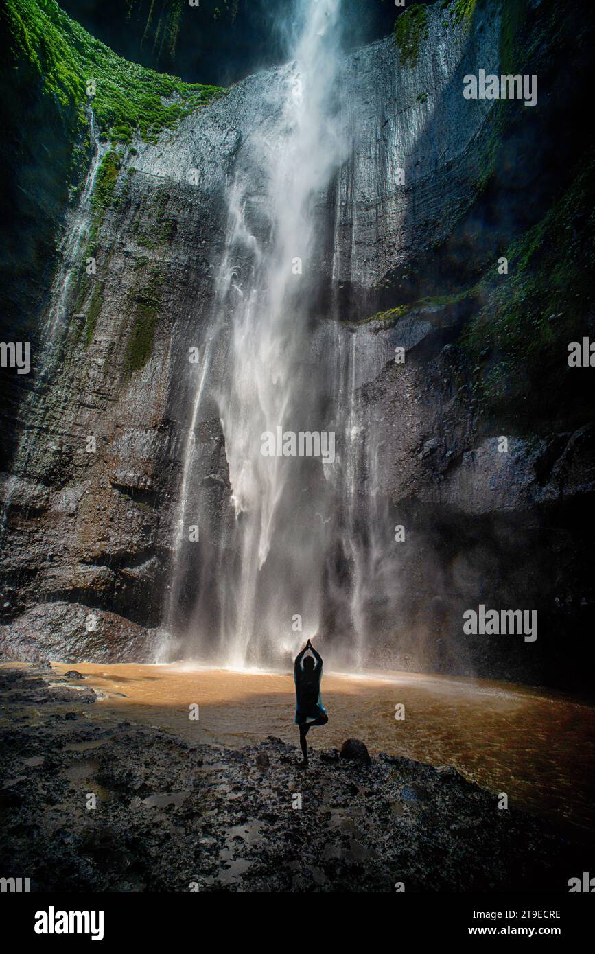 A yoga man in front of the beautiful view of Madakaripura Waterfall ...