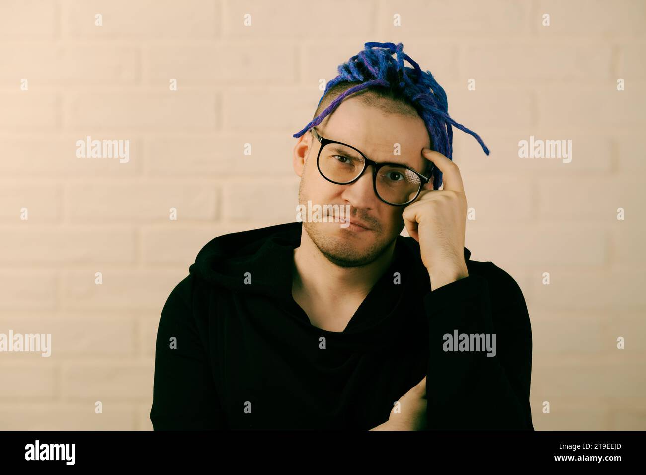 A Thoughtful Man in Glasses and with Vibrant Purple Dreadlocks and a ...