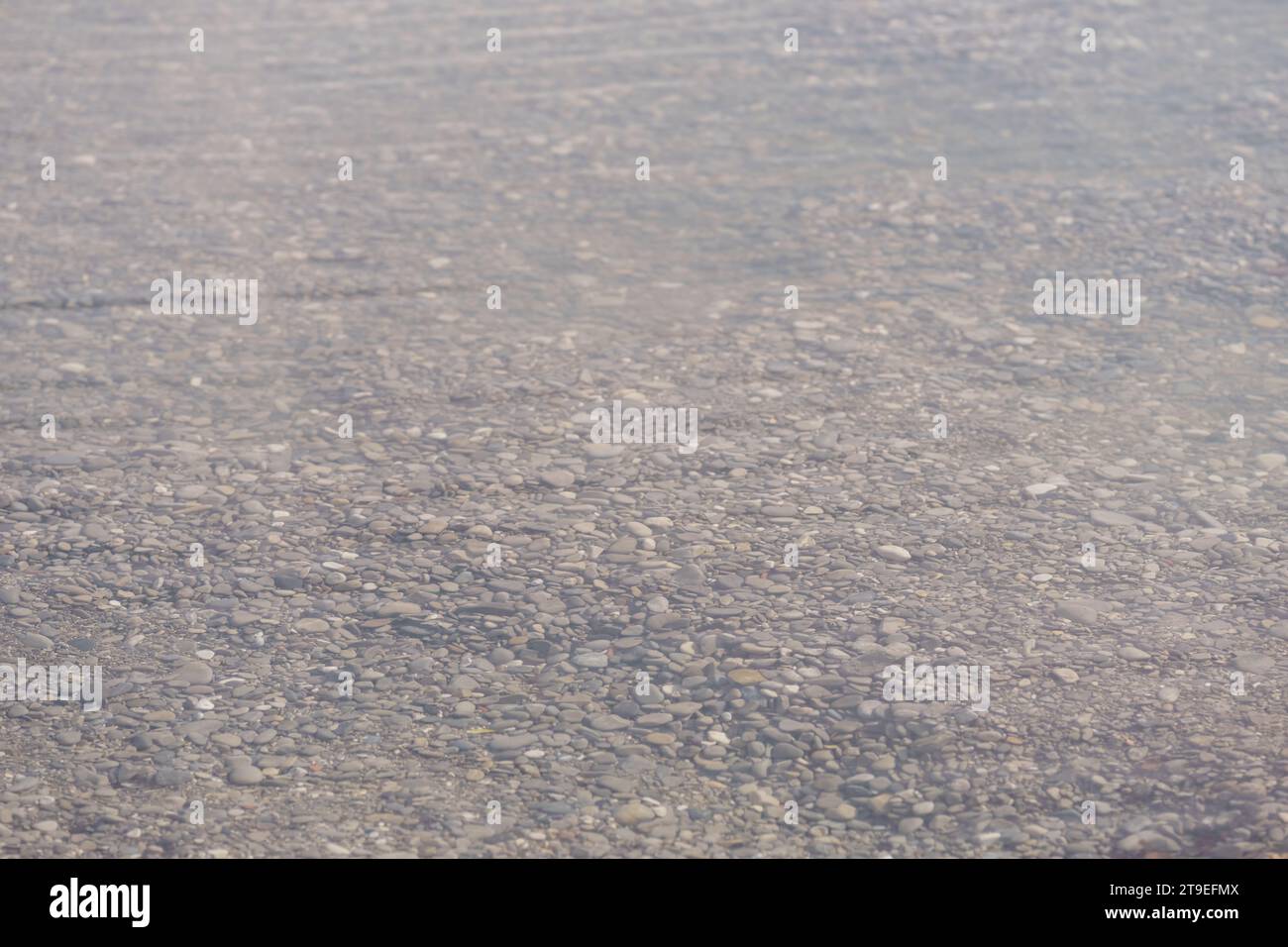 pebbles under shallow water of a mediterranean shore beach, shallow ...