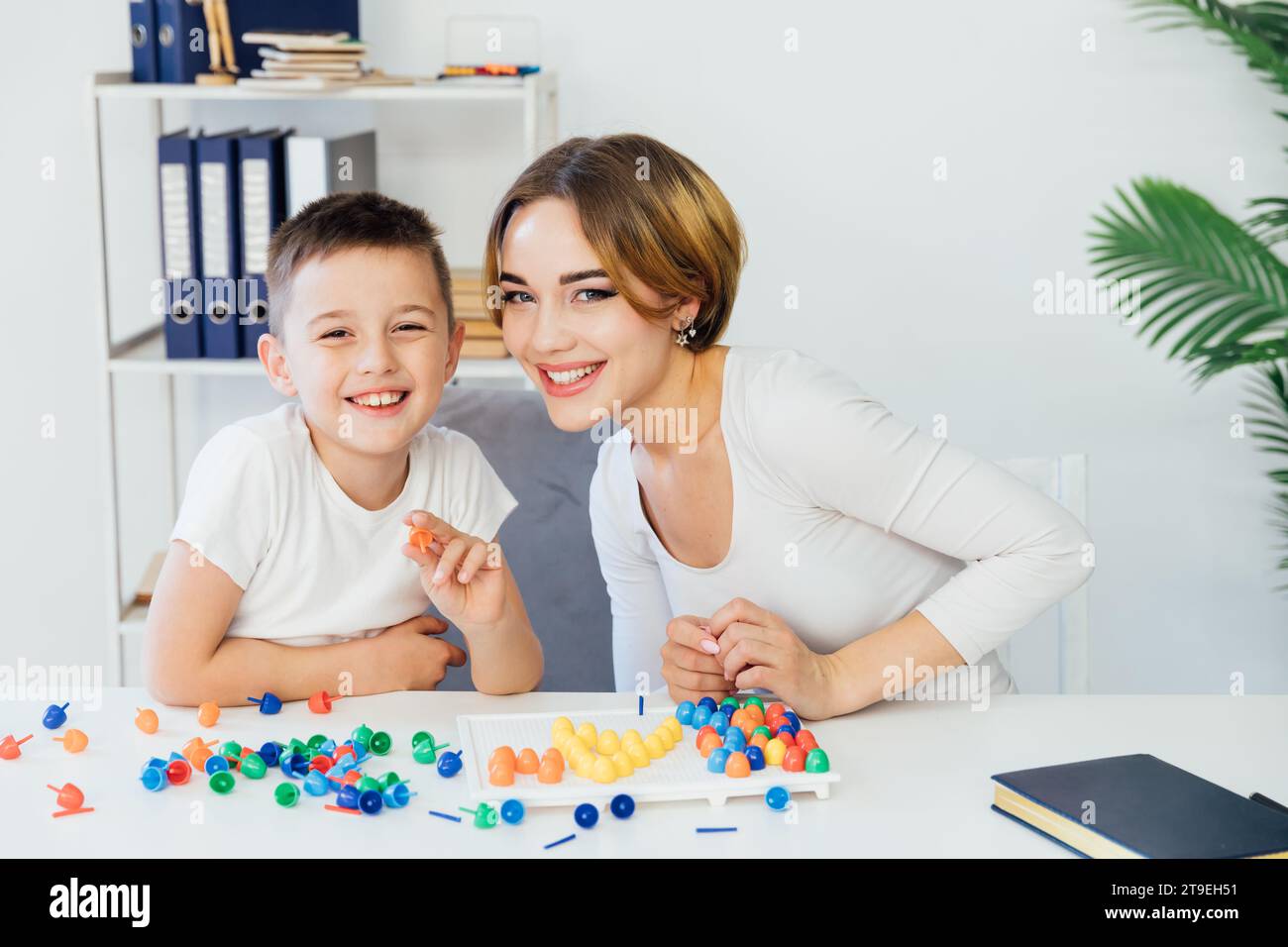 Teacher playing educational games with boy at school Stock Photo - Alamy